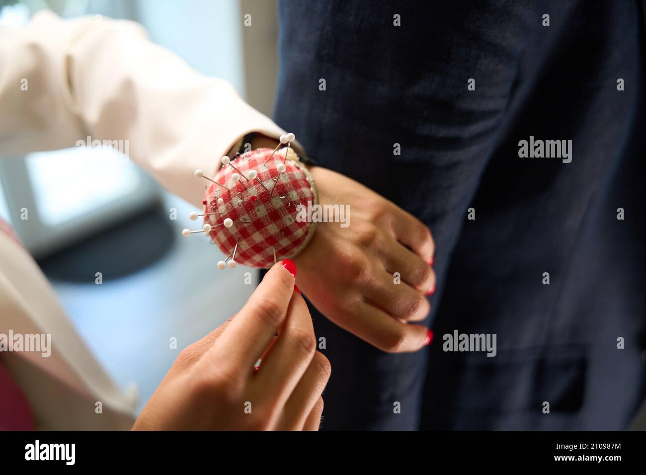 Master tailor adjusting customer clothing during fitting session Stock ...