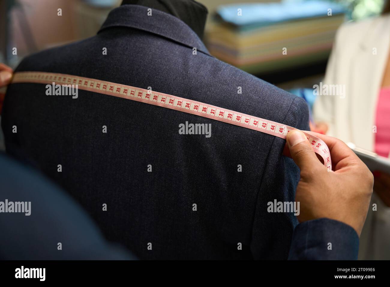 Master tailor taking bespoke garment measurements on dummy Stock Photo ...