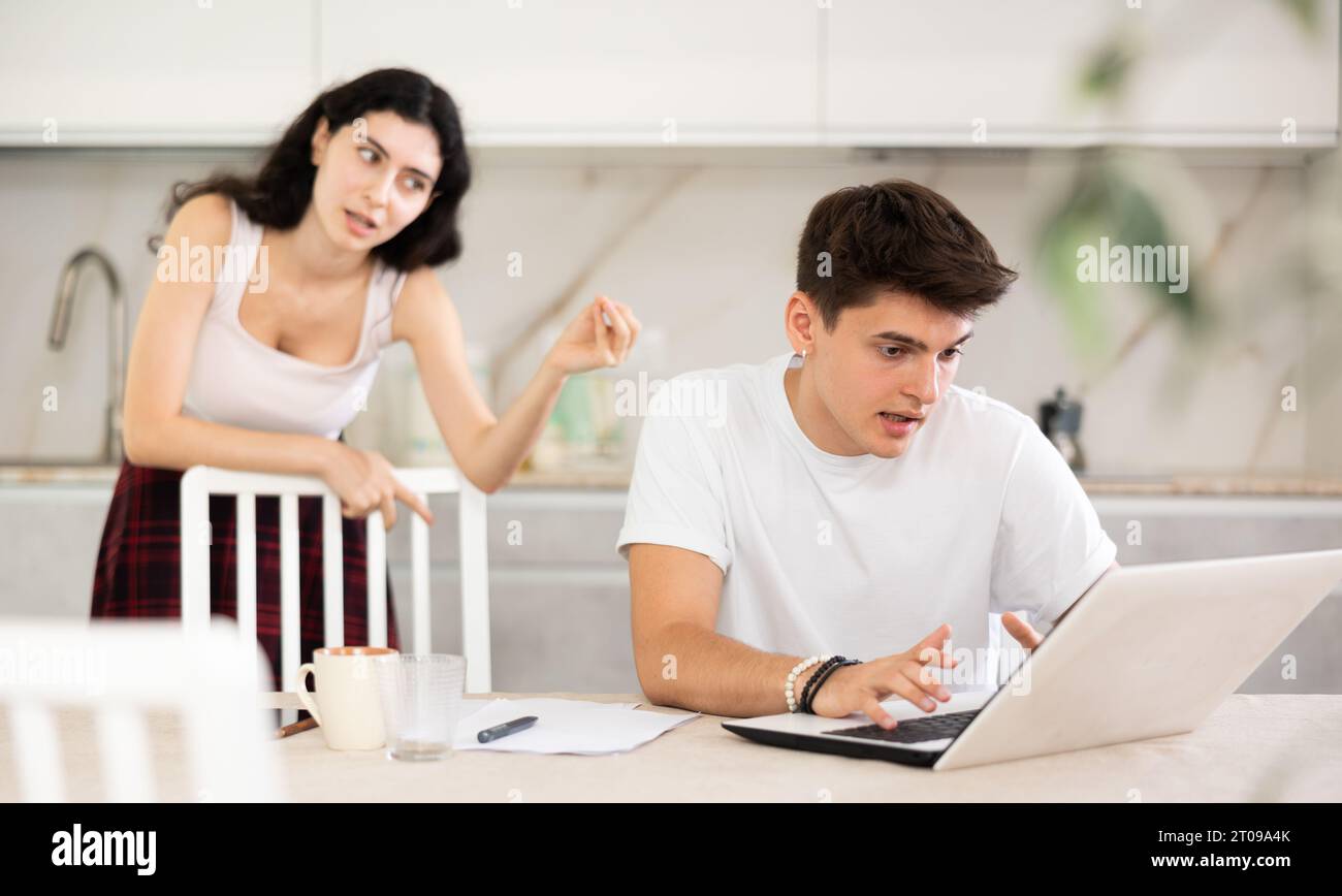 Young woman quarrels with young guy working at laptop Stock Photo - Alamy