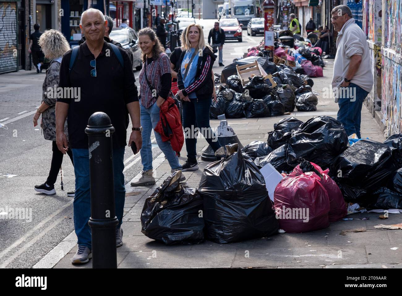 People walk by trash that is piled hi-res stock photography and images ...