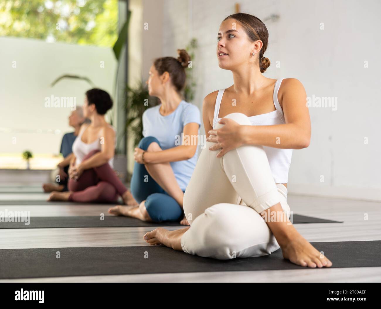 Group of sporty people practicing various yoga positions during ...