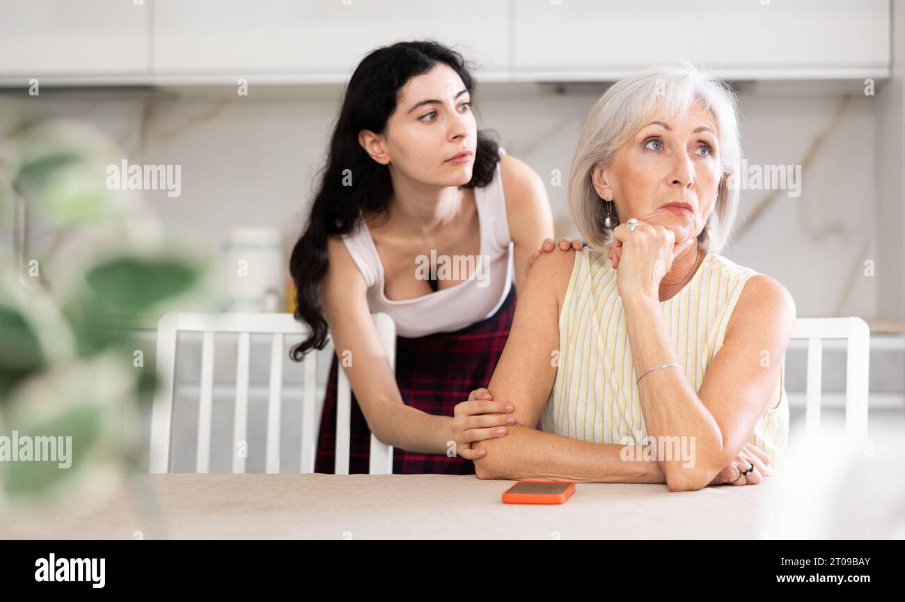 Young woman apologizes to elderly woman after quarrel Stock Photo - Alamy