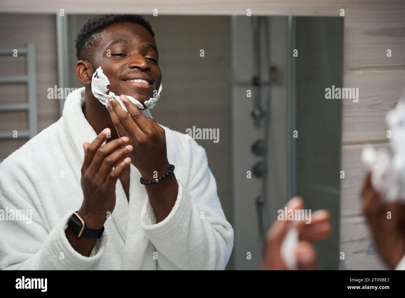 Cute male applies shaving foam to his cheeks Stock Photo - Alamy