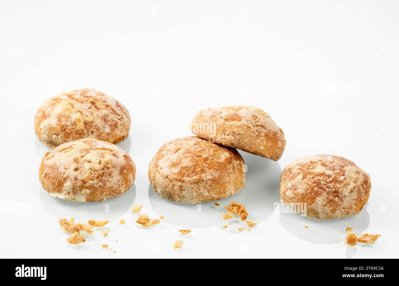 Russian gingerbread-sweet buns on a white mirror background. Crumbs are ...