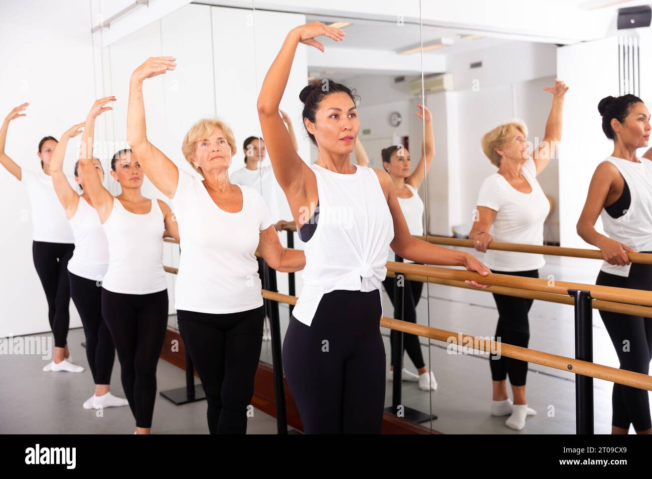 Asian woman rehearsing ballet dance in studio with other dancers Stock ...
