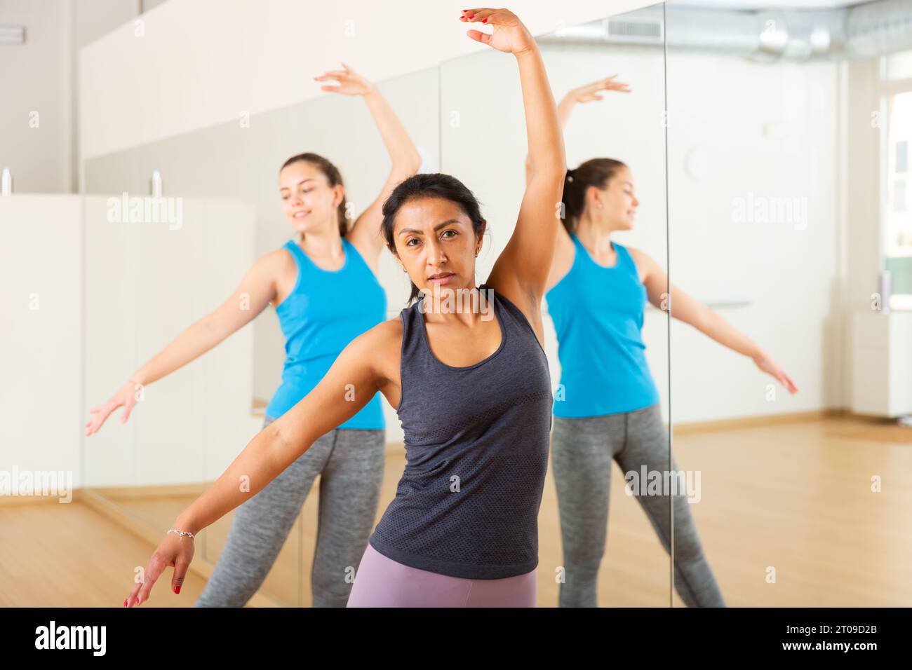 Hispanic woman practicing ballet dance moves in choreographic studio ...