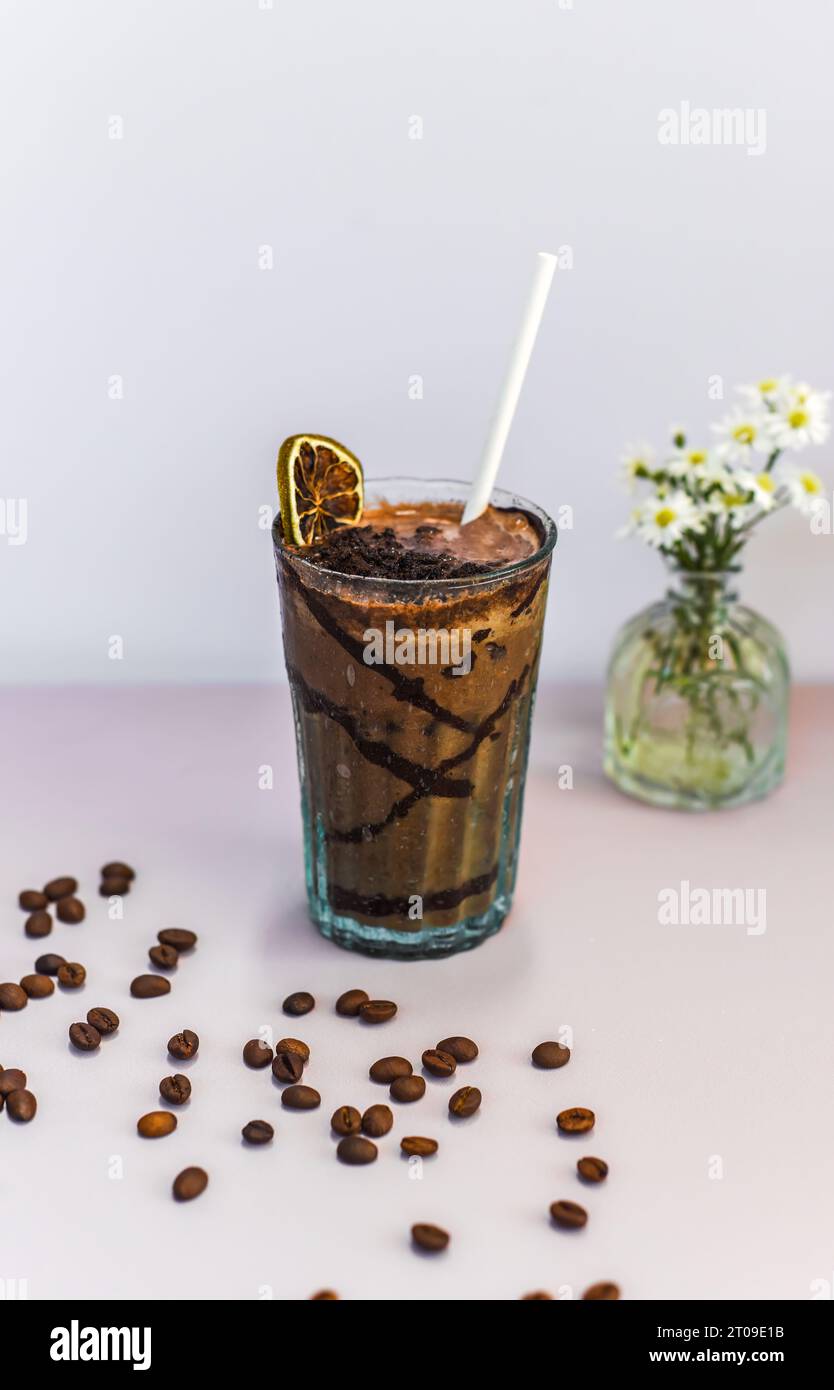 Cacao drink with banana and peanut butter on a table with vase of ...