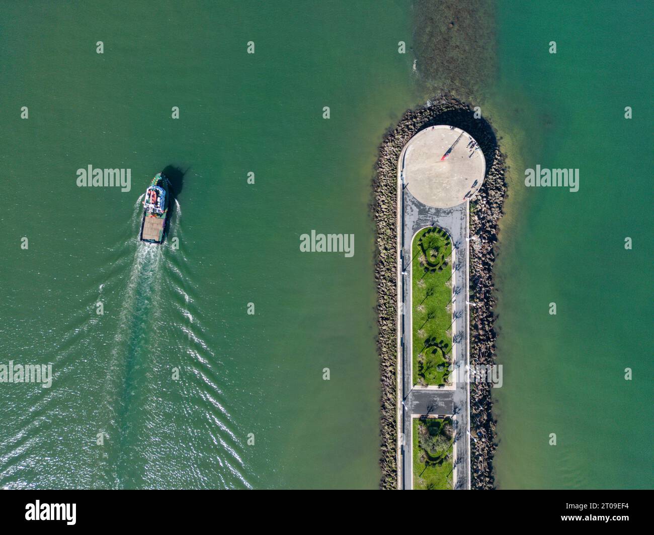Aerial view of yacht leaving trace in calm verdant water while passing ...
