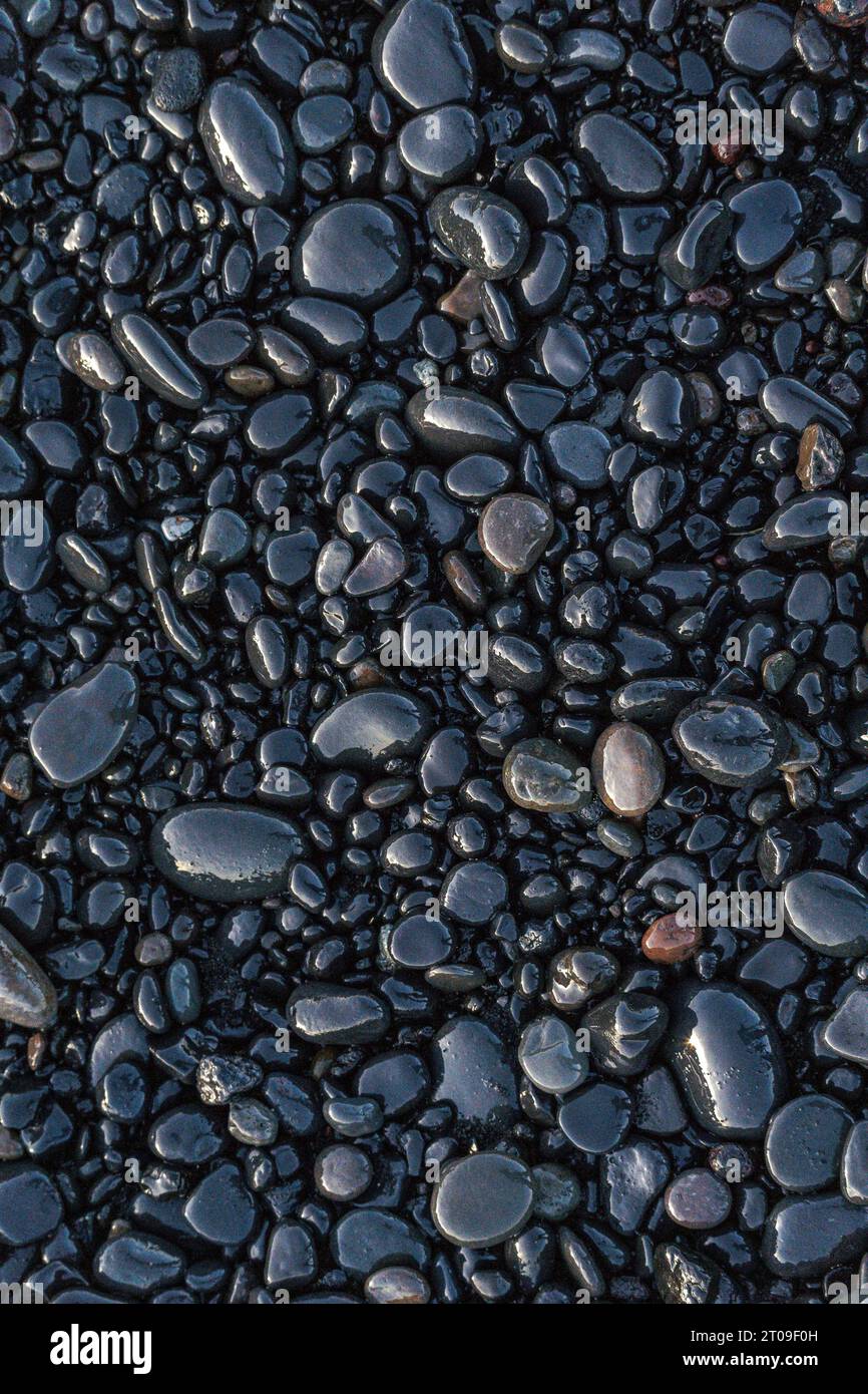 Top view of wet stones located near smooth sedimentary rock on coast in ...