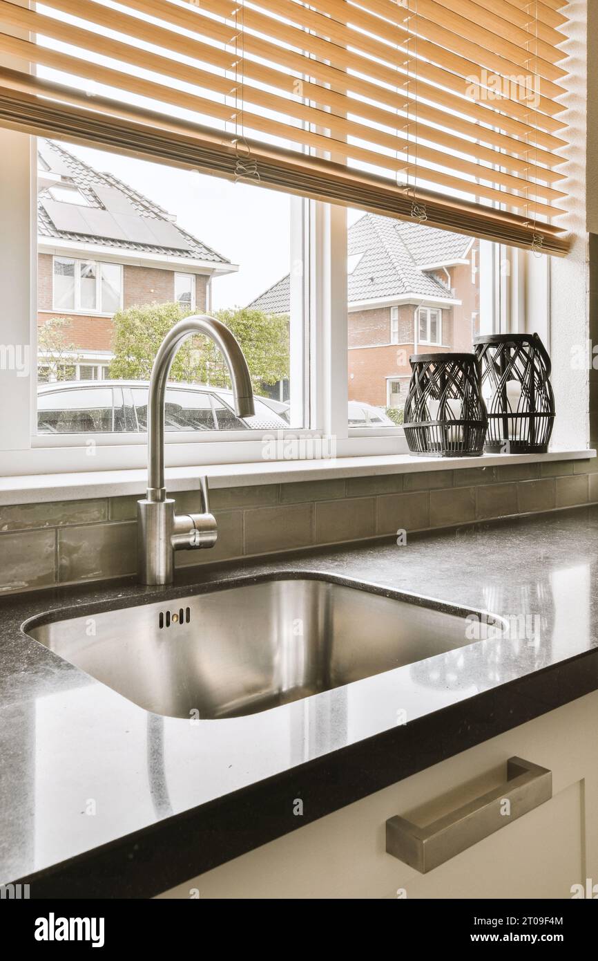 Stainless steel sink and faucet at clean kitchen counter in front of ...