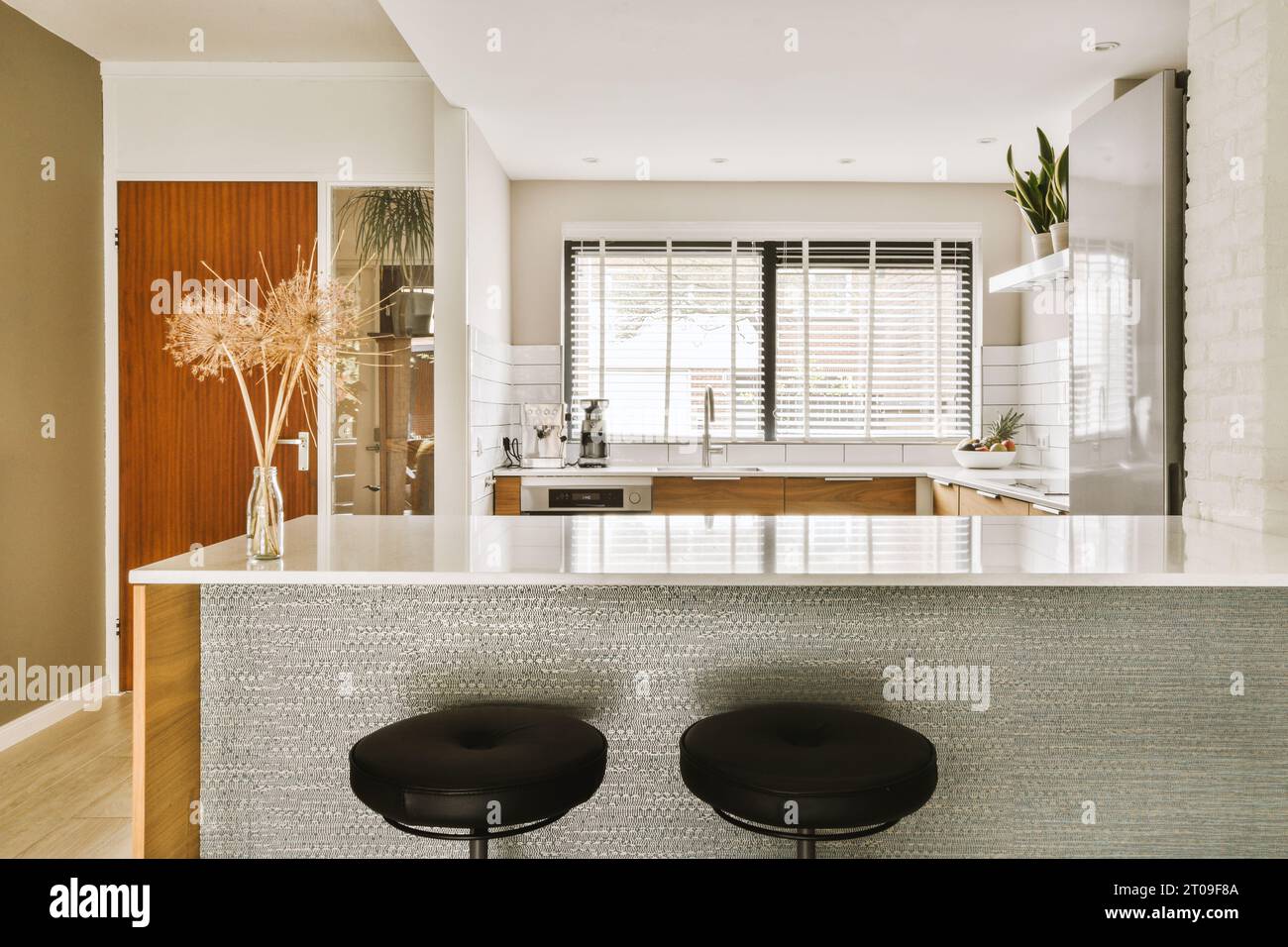 Interior of contemporary house with open kitchen and black stools at ...
