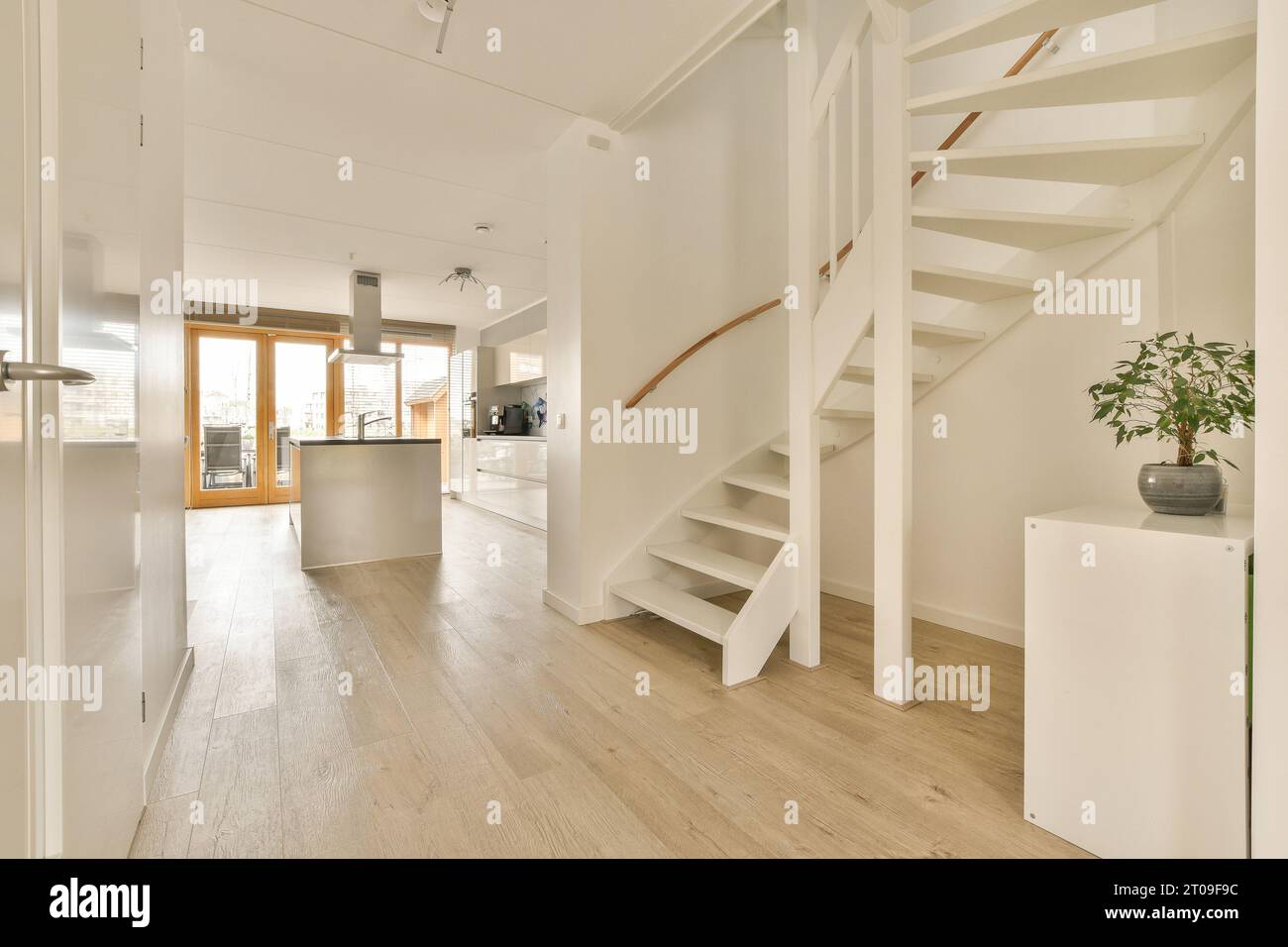 Interior of modern house with white staircase by kitchen seen through ...