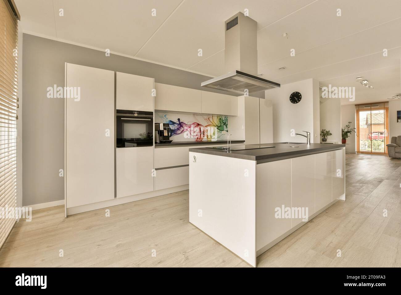 Interior of modern open plan kitchen with rangehood over island in ...