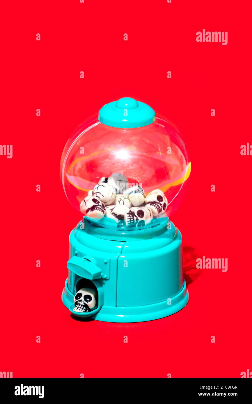 Heap of little human skulls inside transparent round vending machine ...