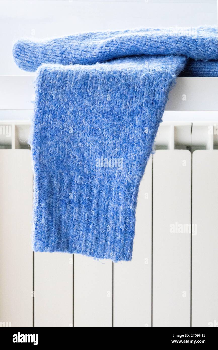 Blue wool sweater drying on a radiator in winter at home. Heating ...