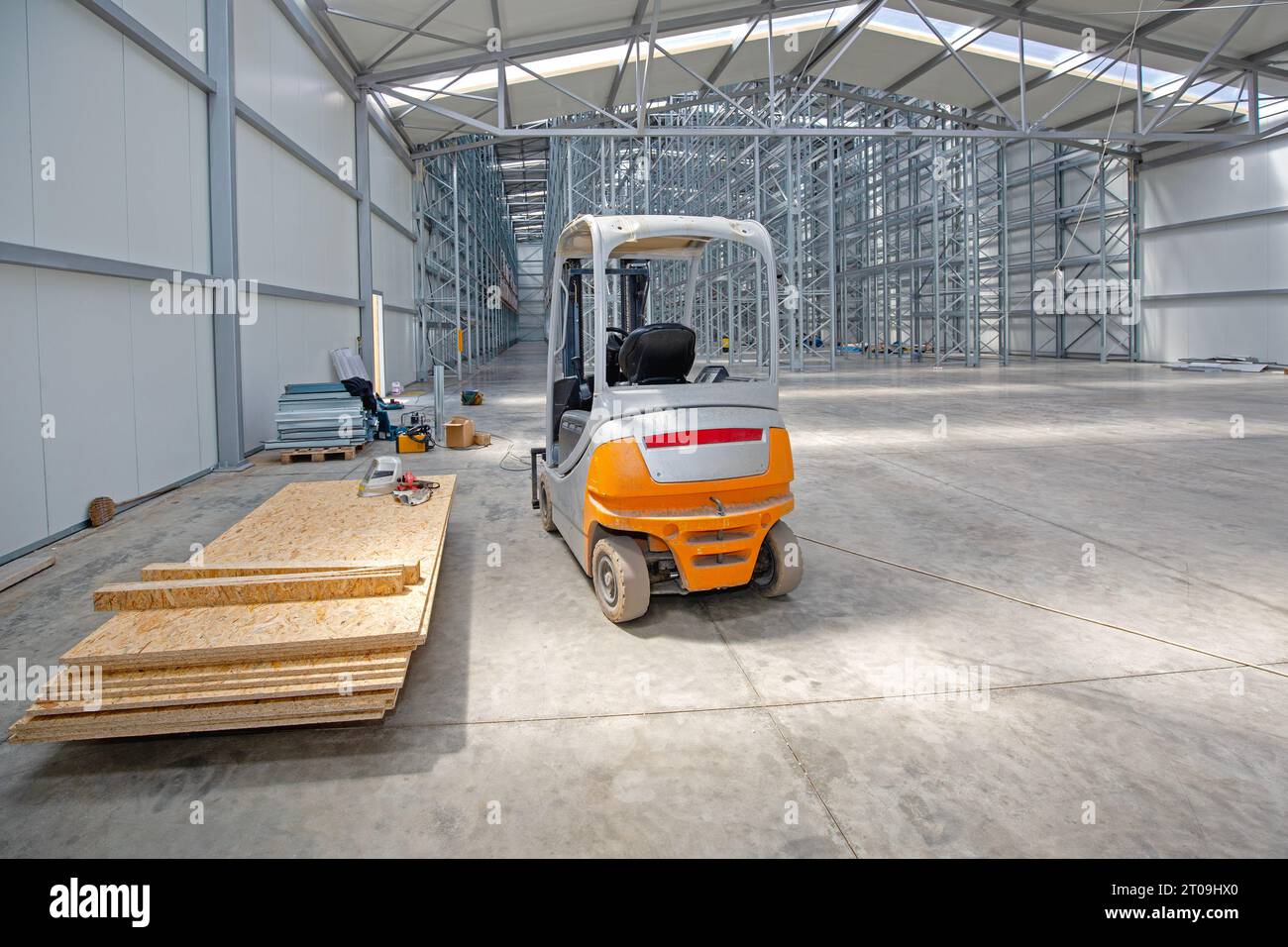 Electric Forklift Truck in Distribution Warehouse Stock Photo - Alamy