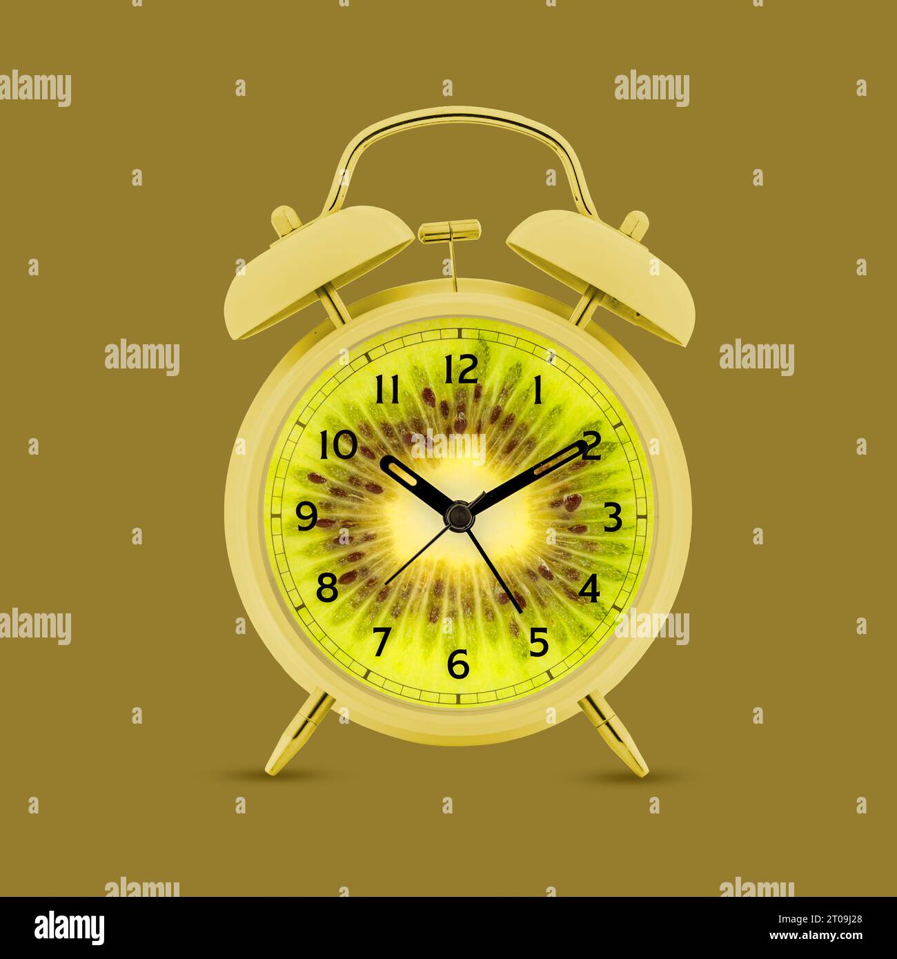 Creative alarm clock with kiwi fruit image over khaki green background ...