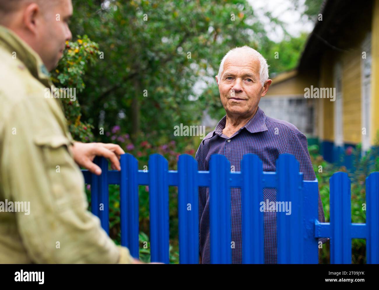 Old man talking with his neighbour Stock Photo - Alamy