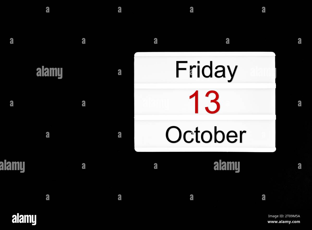 Friday 13th October text on white lightbox sitting on black color ...