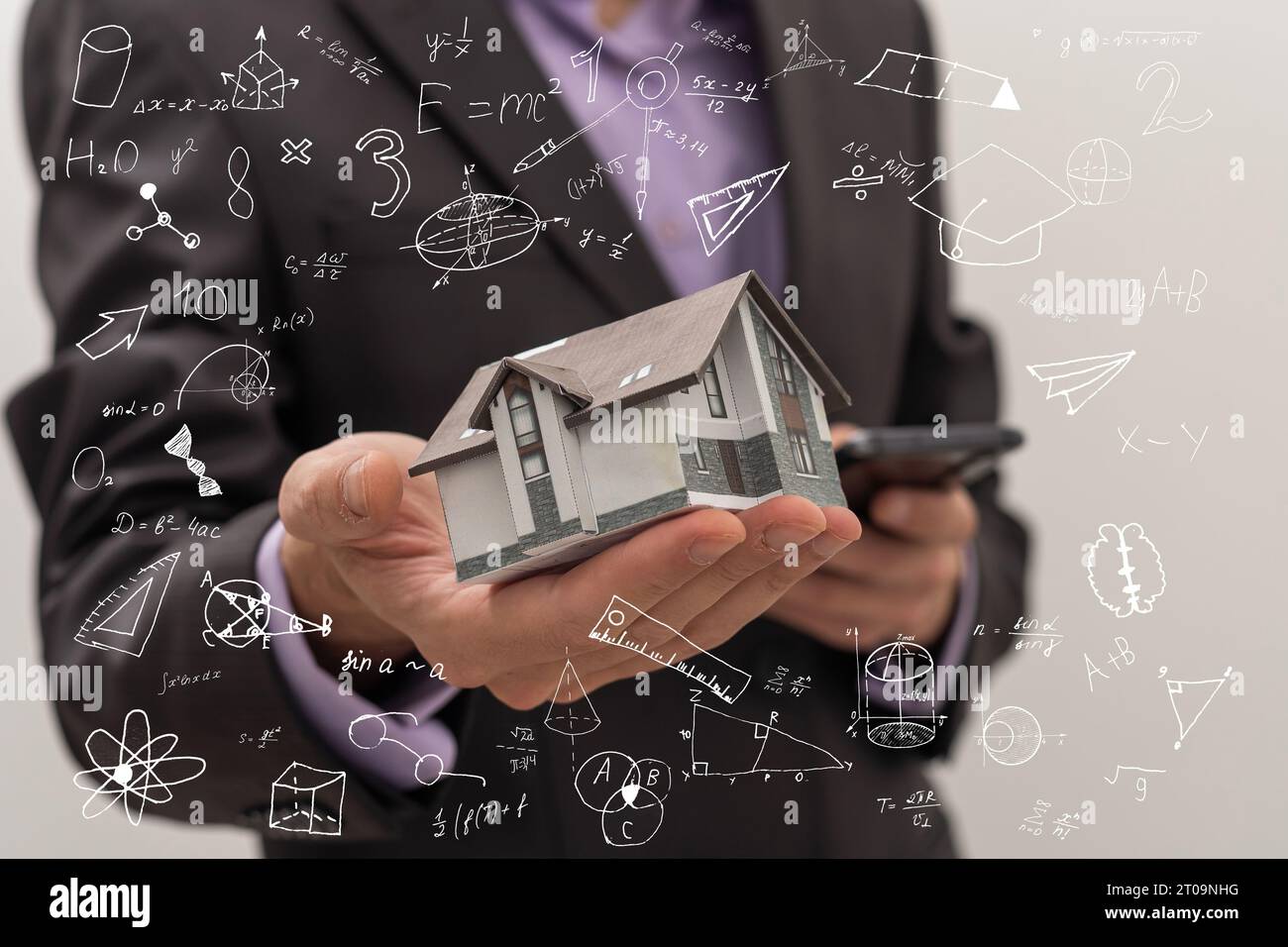 Real estate agent holding a model house on a blue background Stock ...