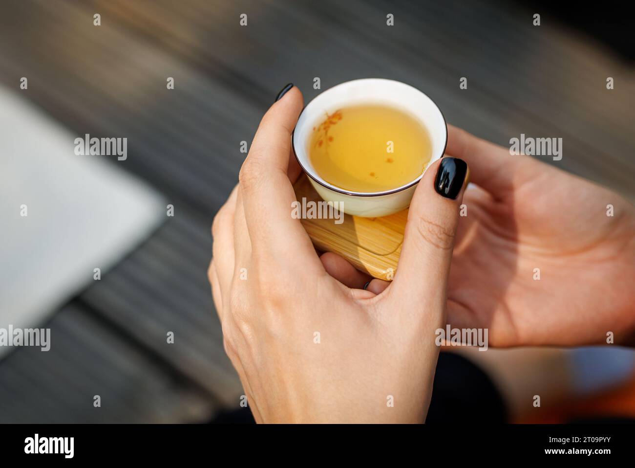 Tiny Chinese teacup in woman's hands during a tea ceremony Stock Photo ...