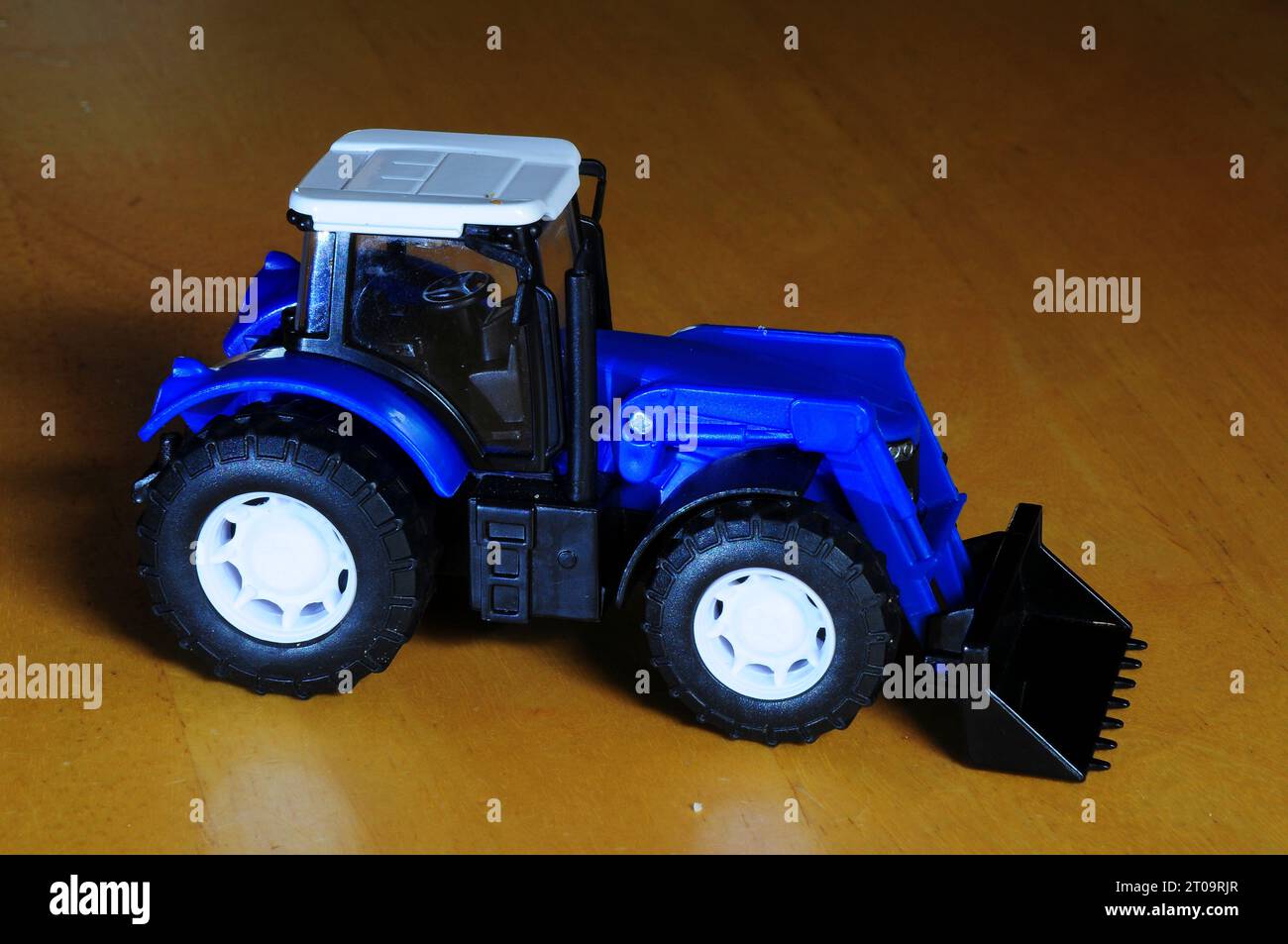 Blue and white toy farm tractor with front loader Stock Photo - Alamy