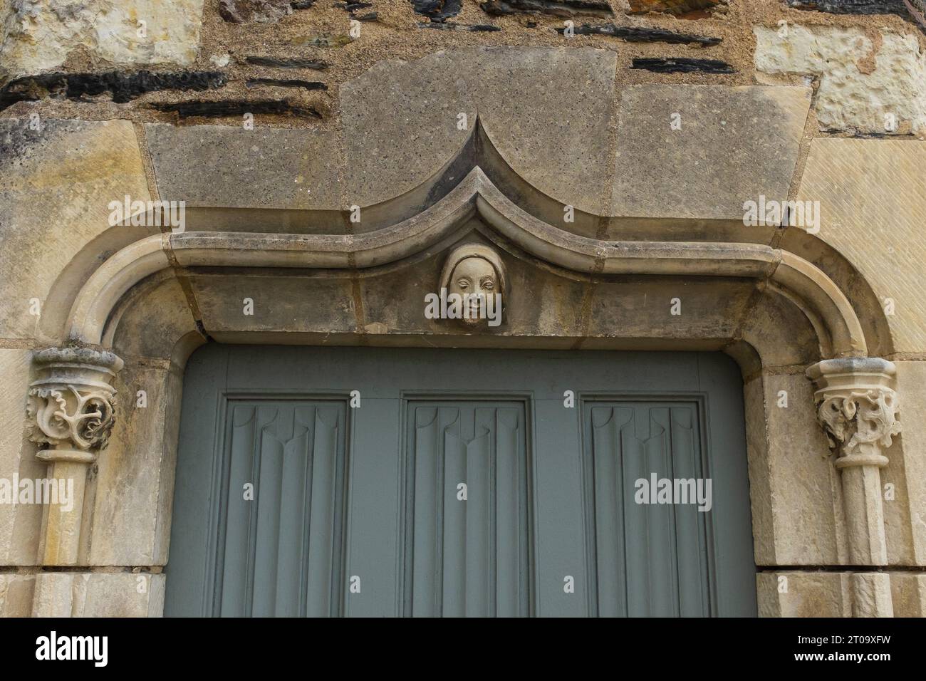 Angers, France, 2023. A medieval sculpted head (mascaron) on the stone ...