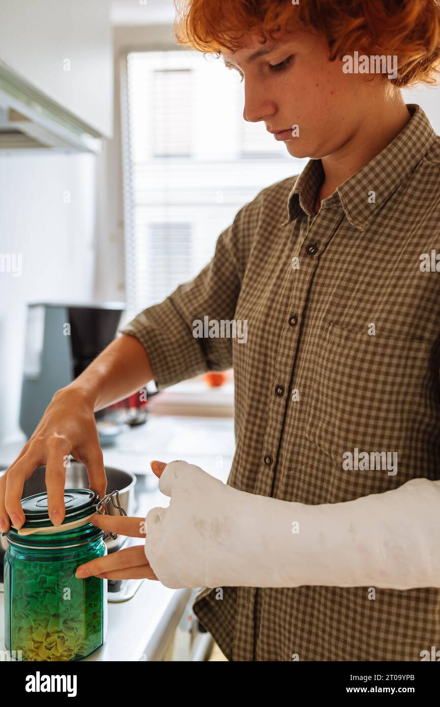 teenage girl, with cast on arm, cook lunch at home Stock Photo - Alamy