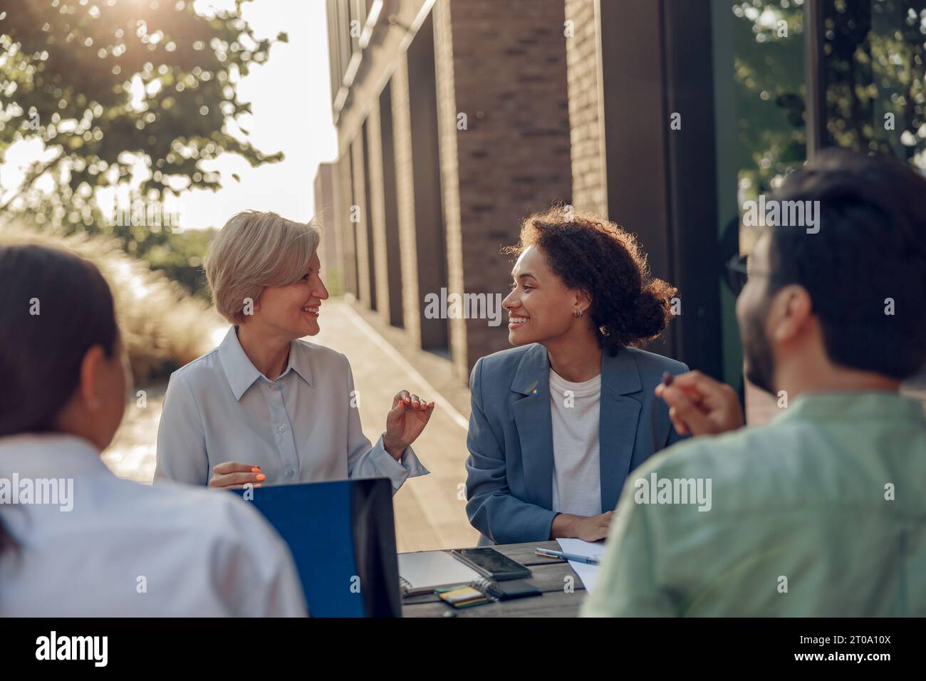 Group of office workers working on the terrace of the office. Teamwork ...