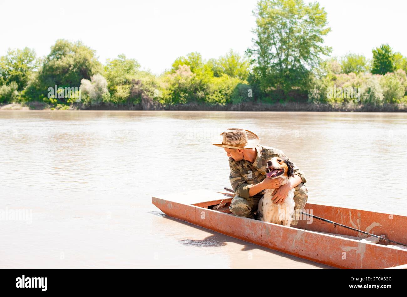 Caring male owner petting happy setter, while floating during morning ...