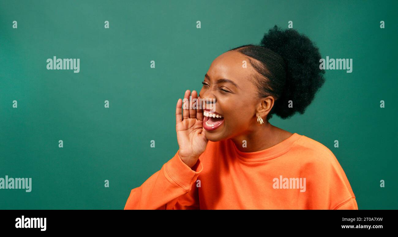 Young Black woman raises hand, yells excitedly to come over green ...