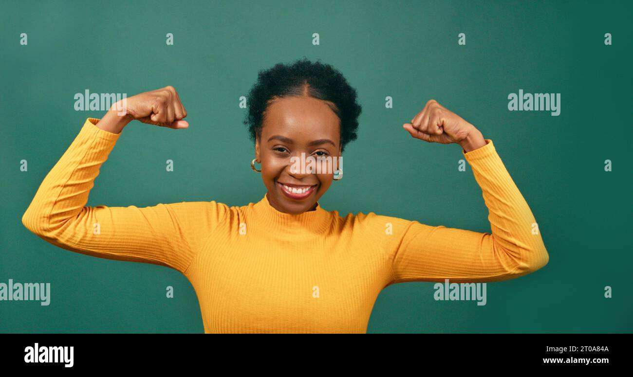 Beautiful strong woman flexes both arms, muscle, green studio ...