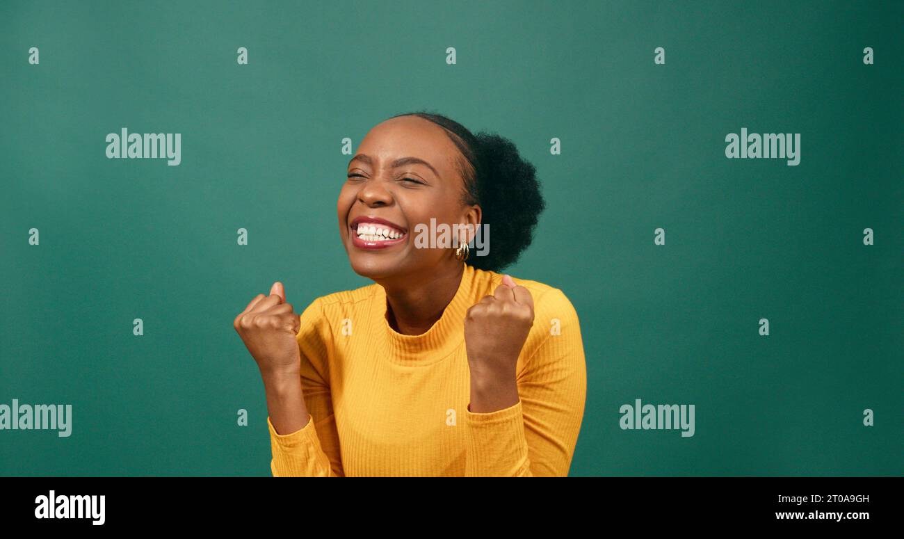Excited woman cheers, winning happy dance, green studio background ...