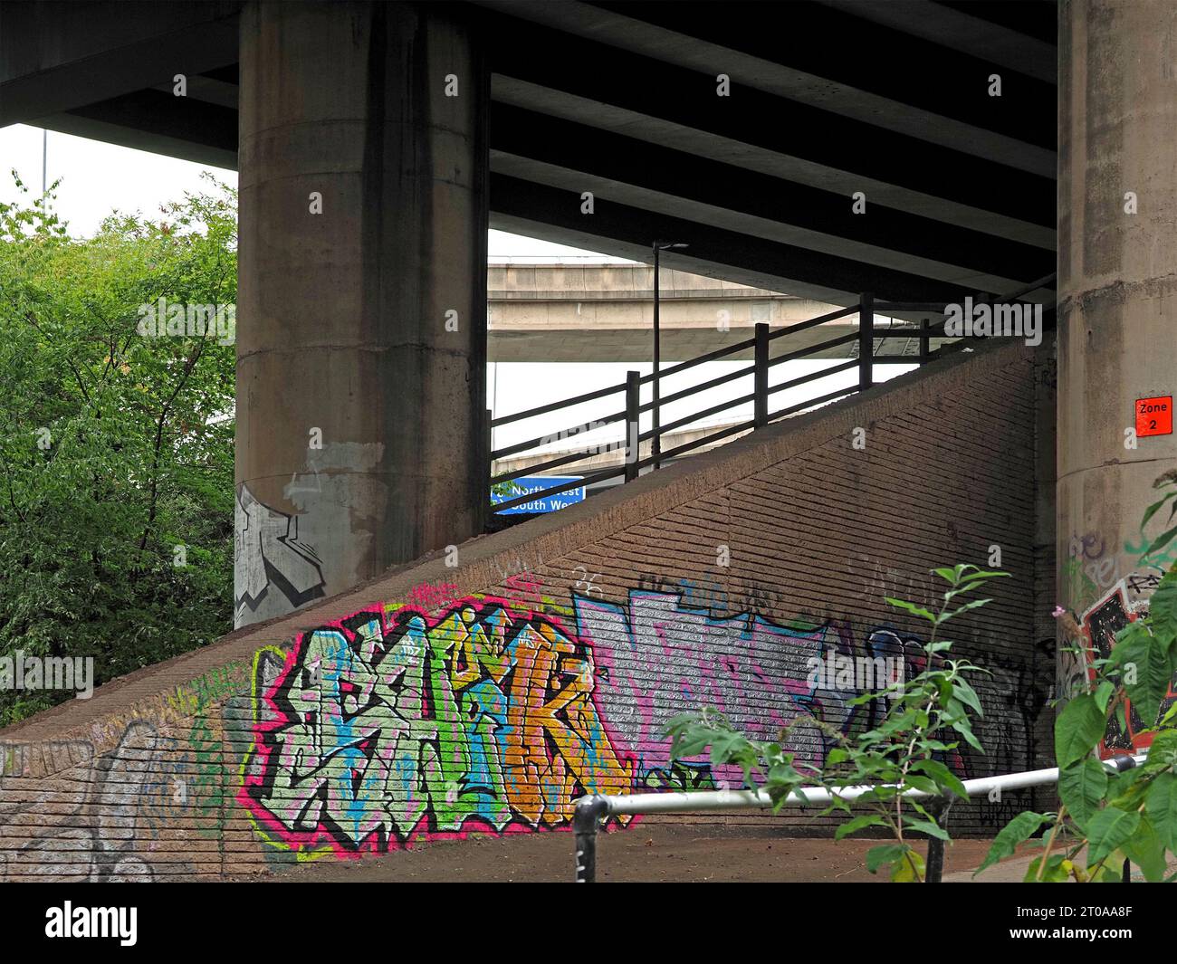 colourful graffiti on brick wall and concrete supporting pillar of ...