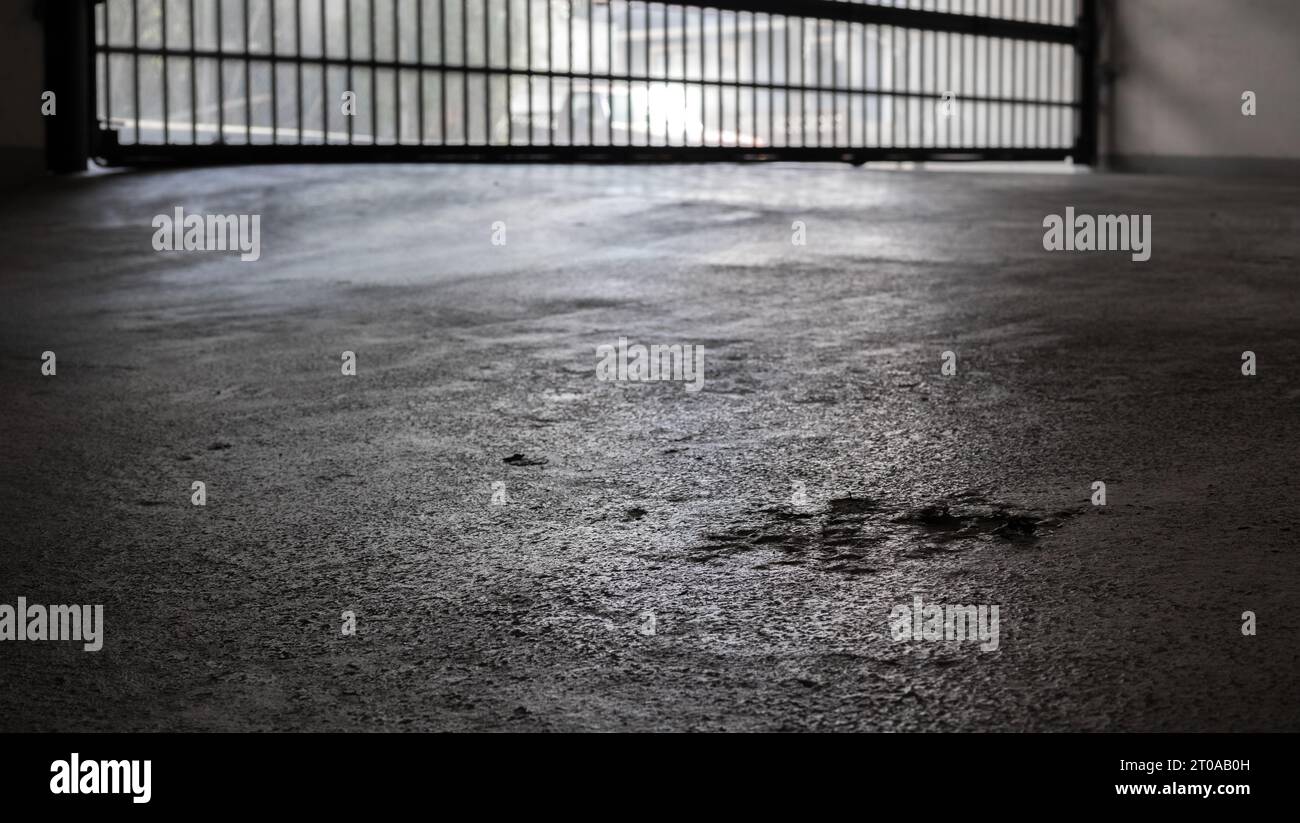 Defocused parking garage gate with focus on driveway, low angle. Secure ...