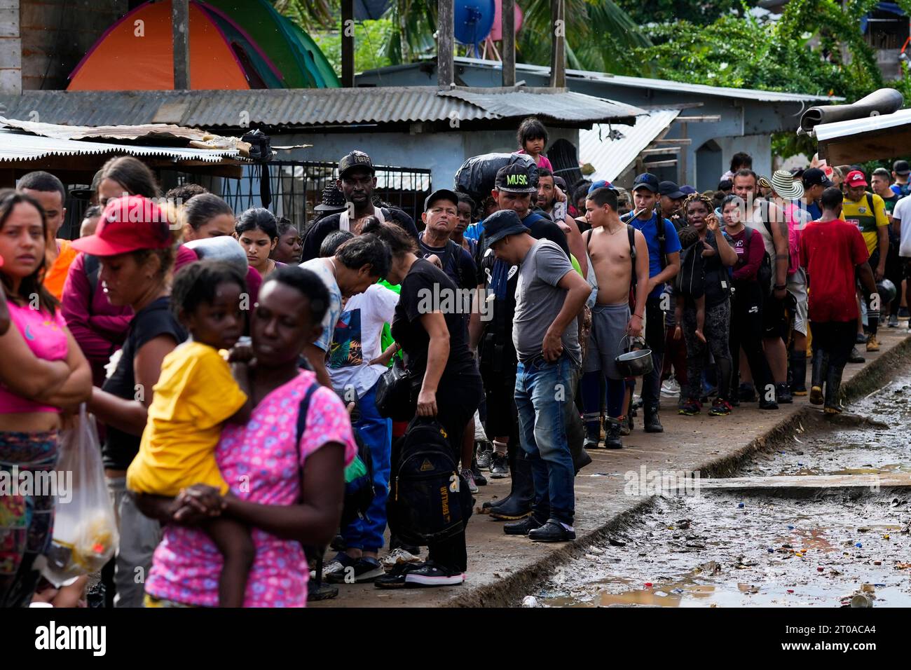 Migrants line up to show their IDs to Panamanian immigration officials ...