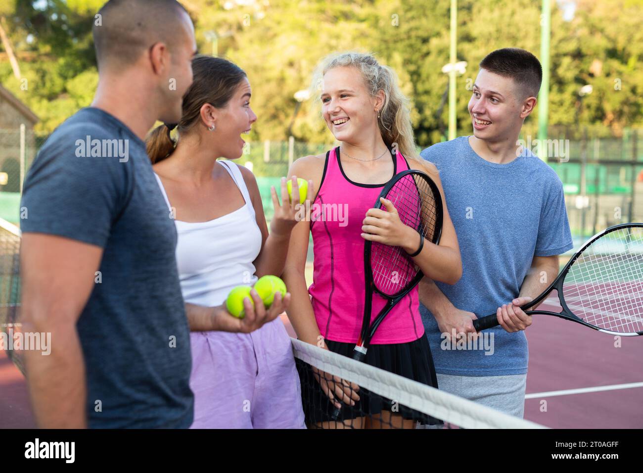 Four tennis players standing on court and talking about match Stock Photo - Alamy