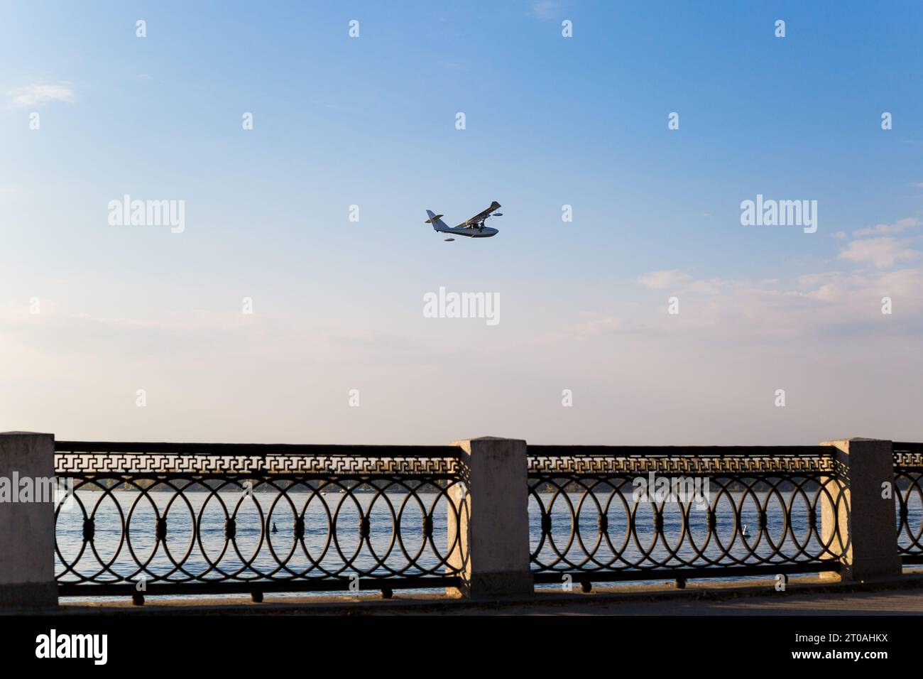 Private small plane flies over the river Stock Photo - Alamy