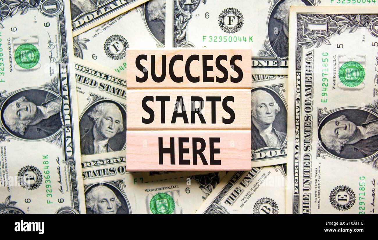 Success starts here symbol. Concept word Success starts here on beautiful wooden block. Dollar ...