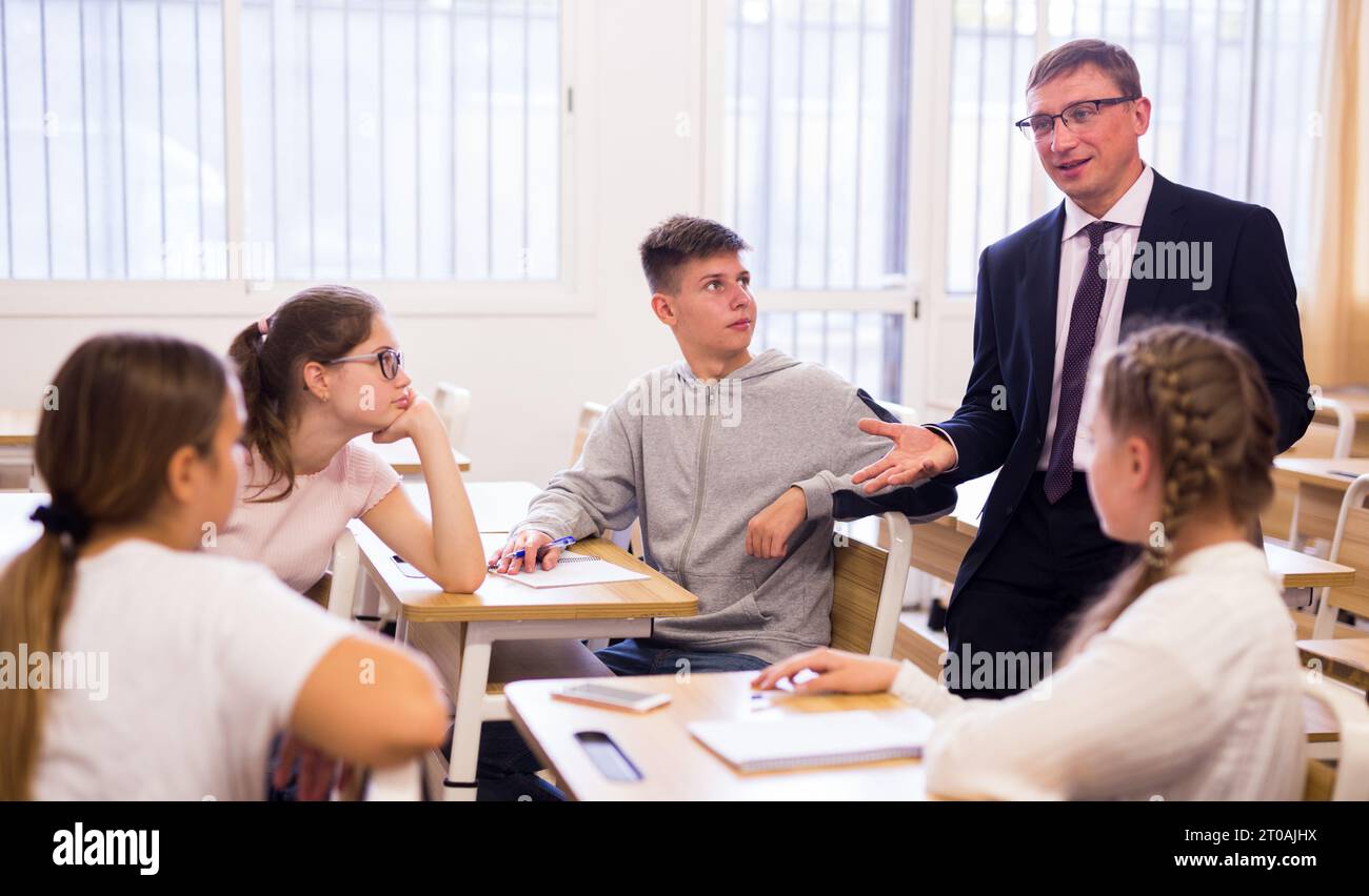 Male teacher lecturing to students at classroom Stock Photo - Alamy
