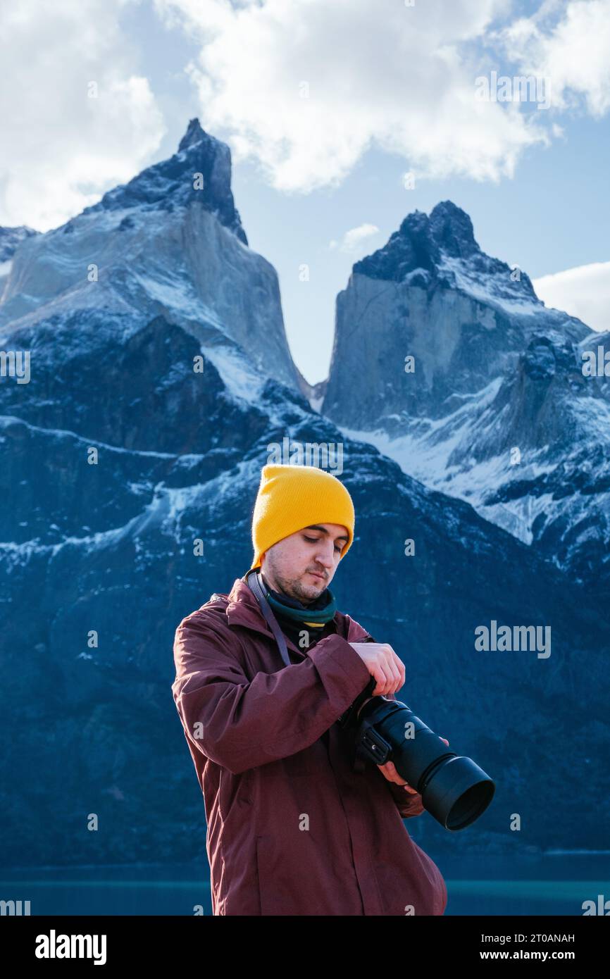 A vertical shot of a young male photographer in Torres del Paine ...