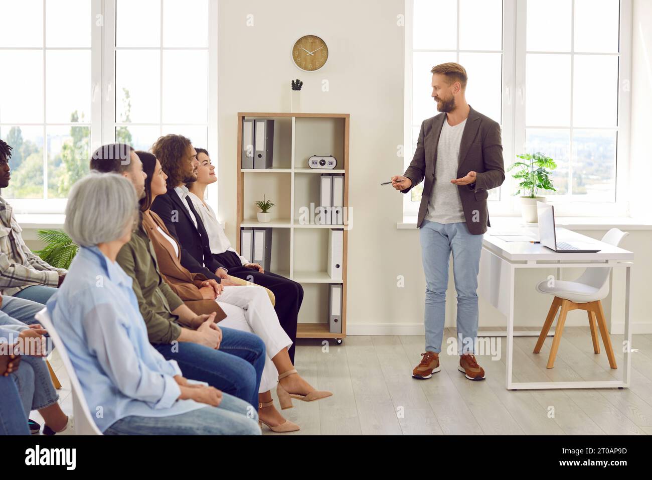 Business man speaking on a meeting in the office in front of a small ...