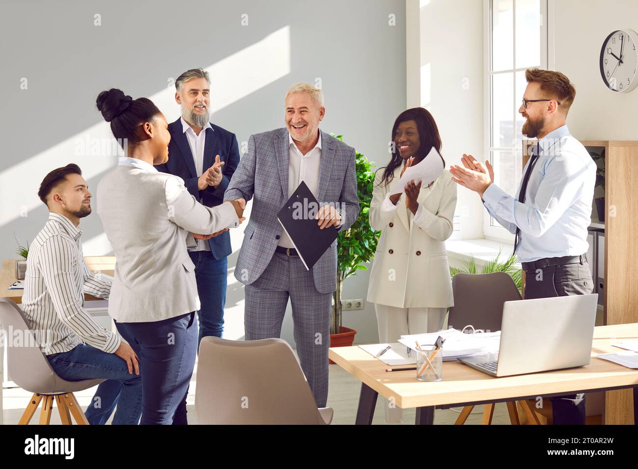 Business staff applauding new hired employee during meeting in office ...
