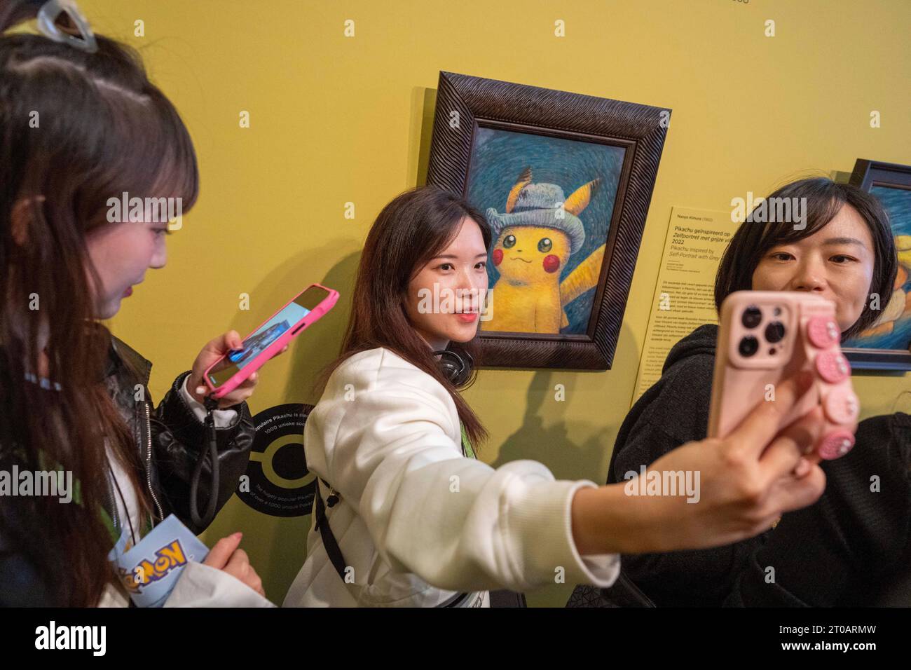 Visitors pose with a painting of Pikachu at the Van Gogh Museum which ...
