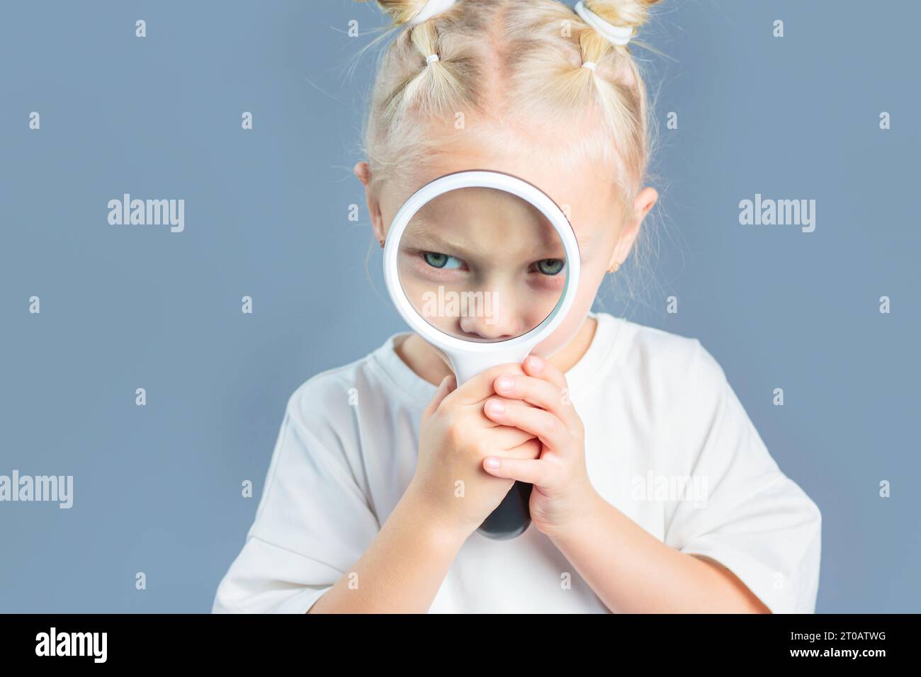 Curious girl looking through magnifying glass Stock Photo - Alamy