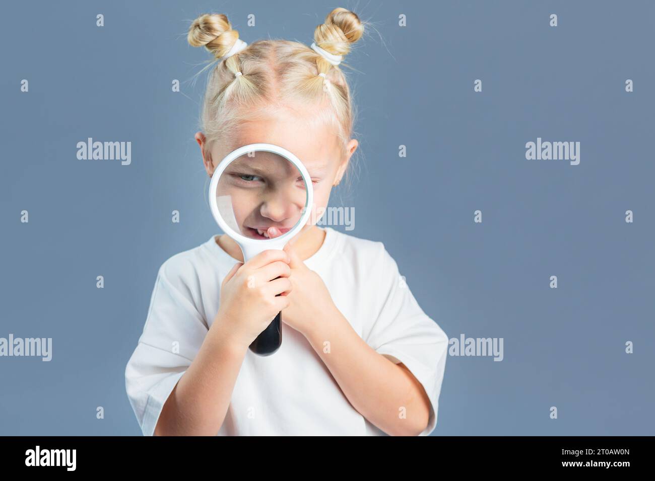 Curious girl looking through magnifying glass Stock Photo - Alamy