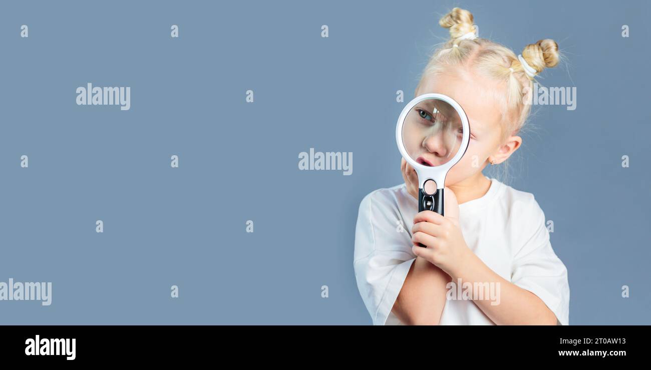 Curious girl looking through magnifying glass Stock Photo - Alamy