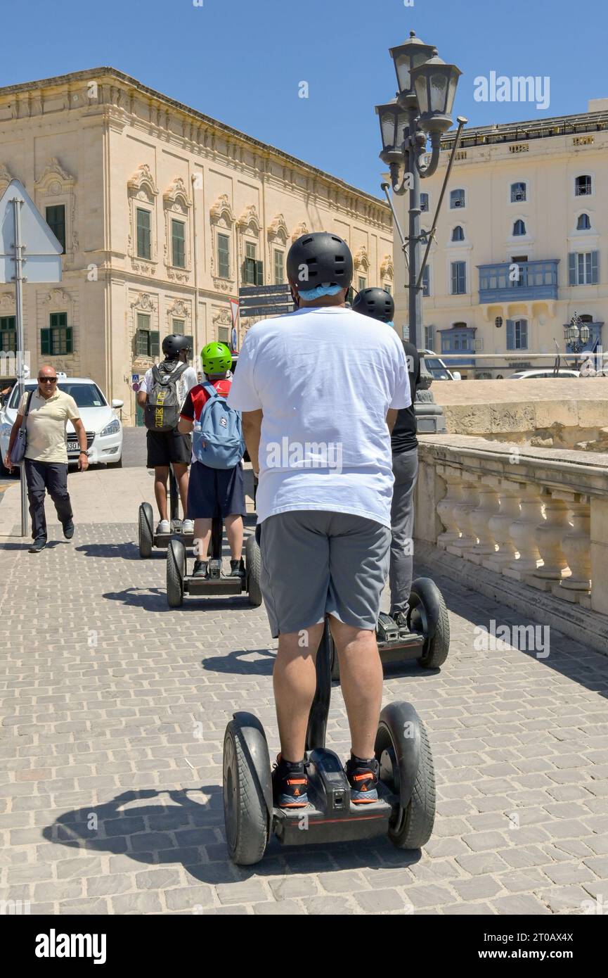 Valletta, Malta - 3 August 2023: Group of visitors to the city riding ...