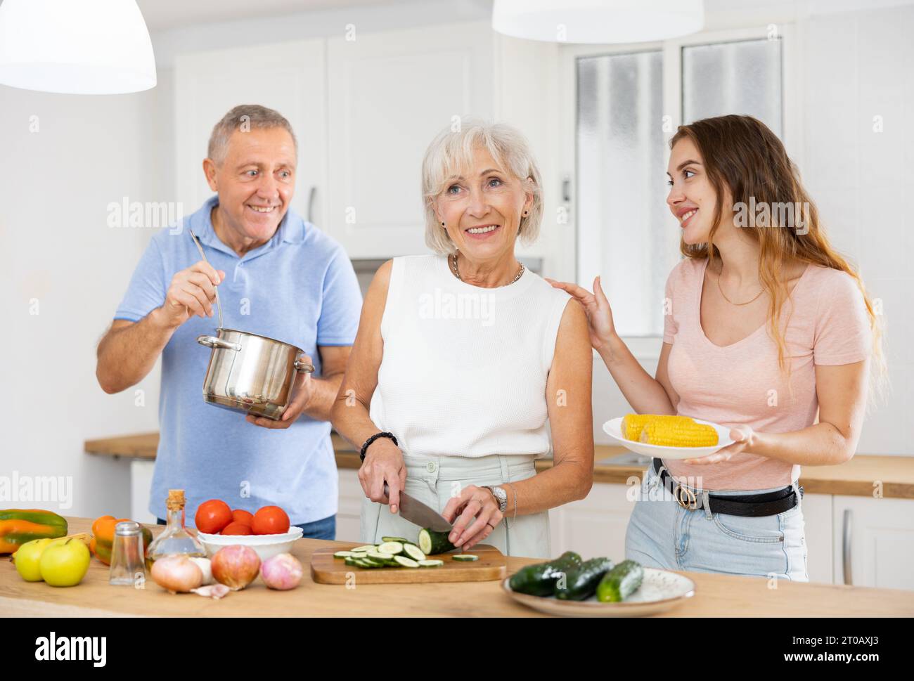 Happy family of three preparing lunch together in modern kitchen Stock ...