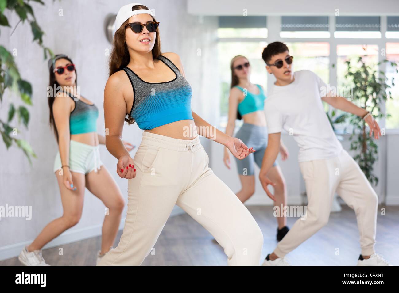 Group of young girls in dark glasses and ball cap and guy dance shuffle ...